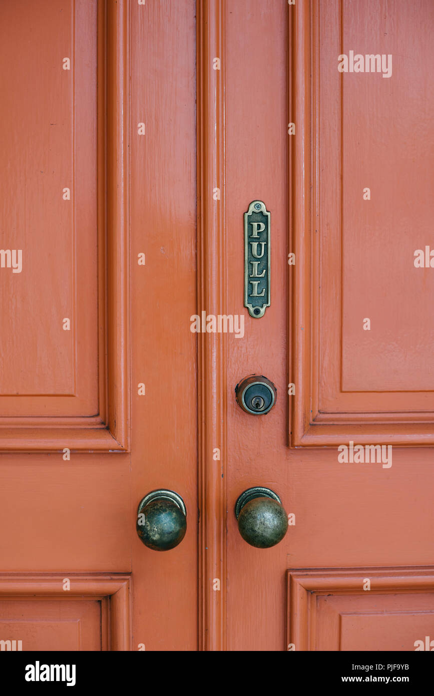 Red doors with ornate framing, old knobs and a pull sign Stock Photo ...