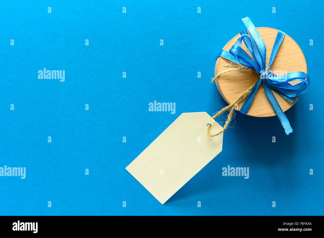 Top view on Christmas gift box decorated with ribbon on blue paper ...
