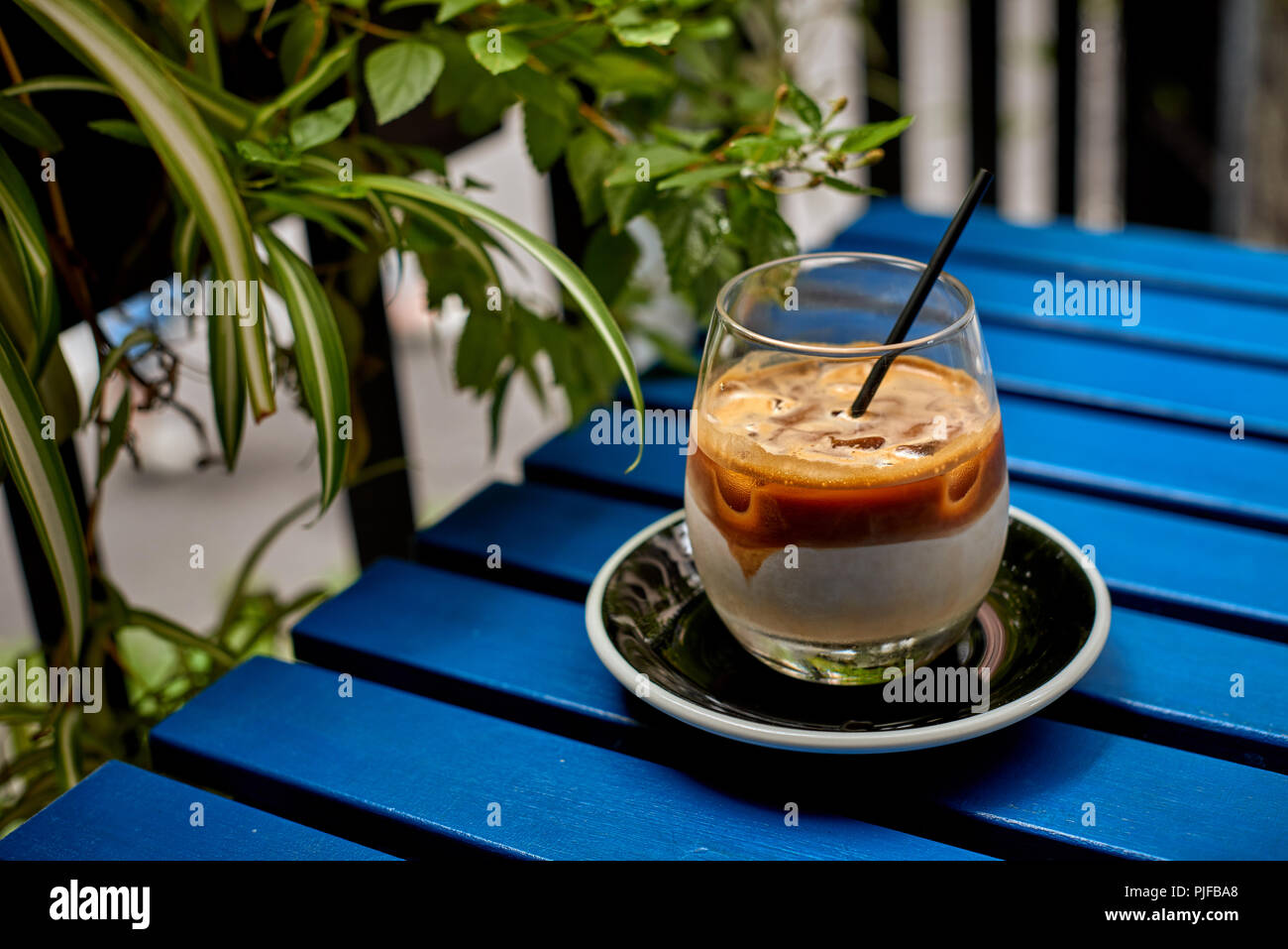 Iced coffee latte on the blue table in the summer Stock Photo - Alamy