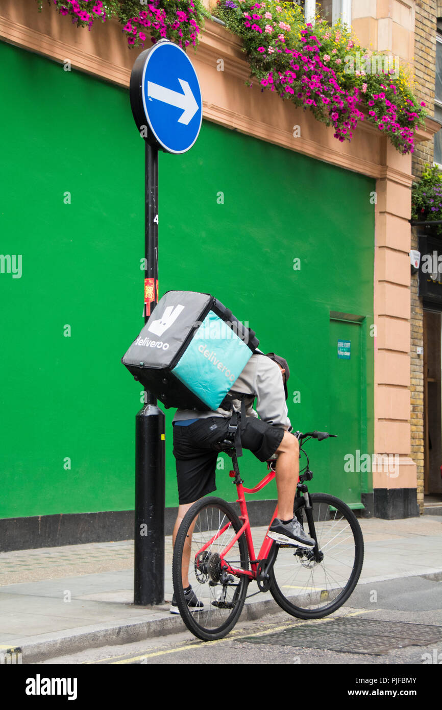 Deliveroo cyclist on a quiet street in London's Soho district, UK Stock ...