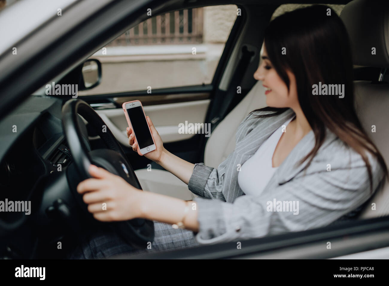 Young Woman Sending Messages while Driving Stock Photo - Alamy