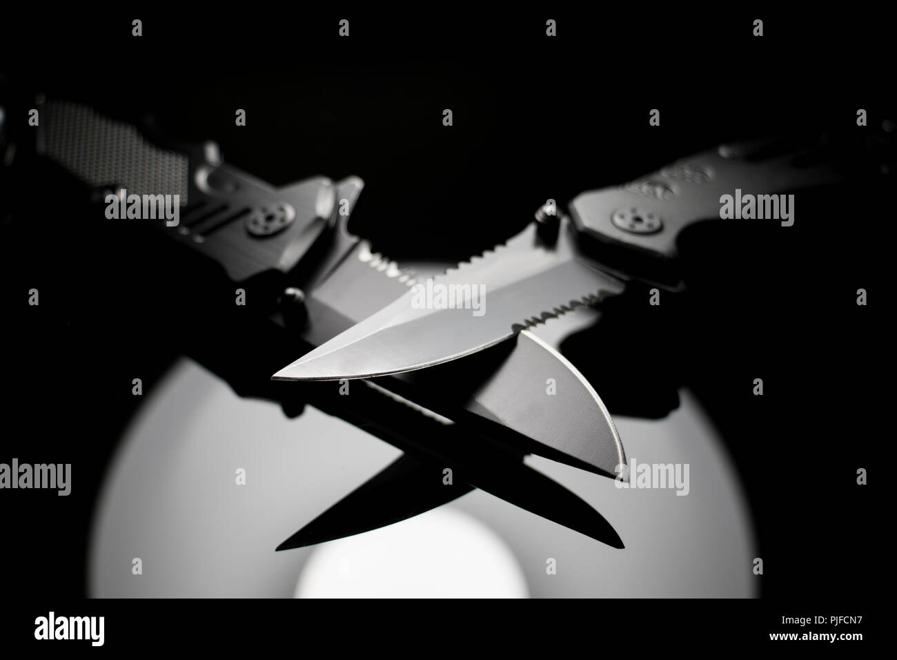 Black tactical knife reflecting on glass. Macro of an army knife with a ...