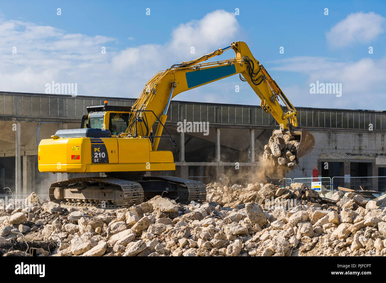Excavator moving demolition rubble Stock Photo - Alamy