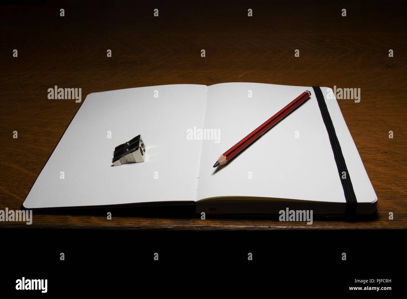 Open sketchbook on the desk of an artist. Art studio objects. Tools of ...