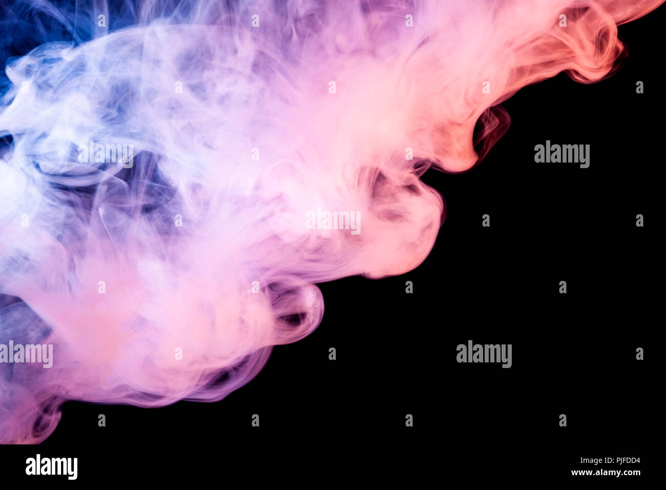 Dense multicolored smoke of pink, blue and purple colors on a black ...