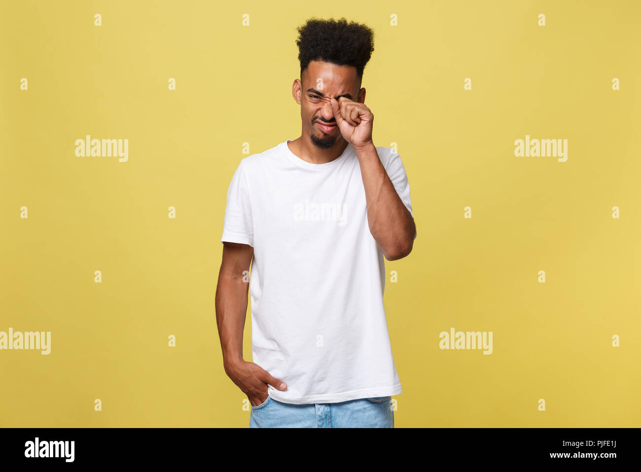 Closeup portrait man with sad expression, isolated on yellow wall ...