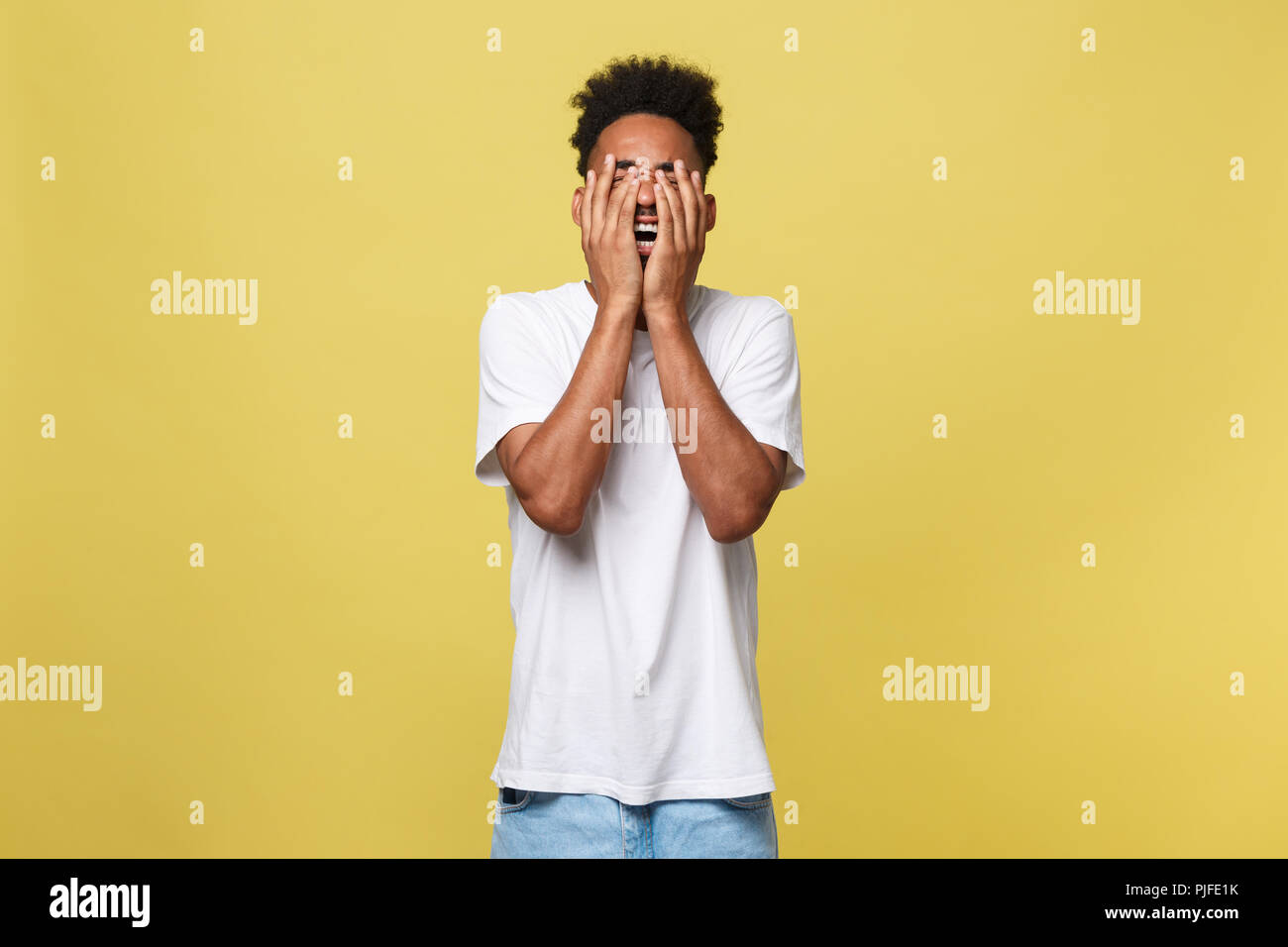 Closeup portrait man with sad expression, isolated on yellow wall ...