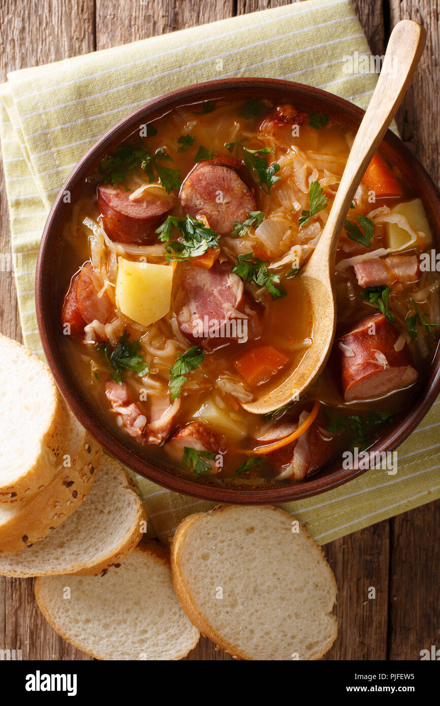 Delicious soup of sauerkraut with sausages and vegetables close-up in a ...