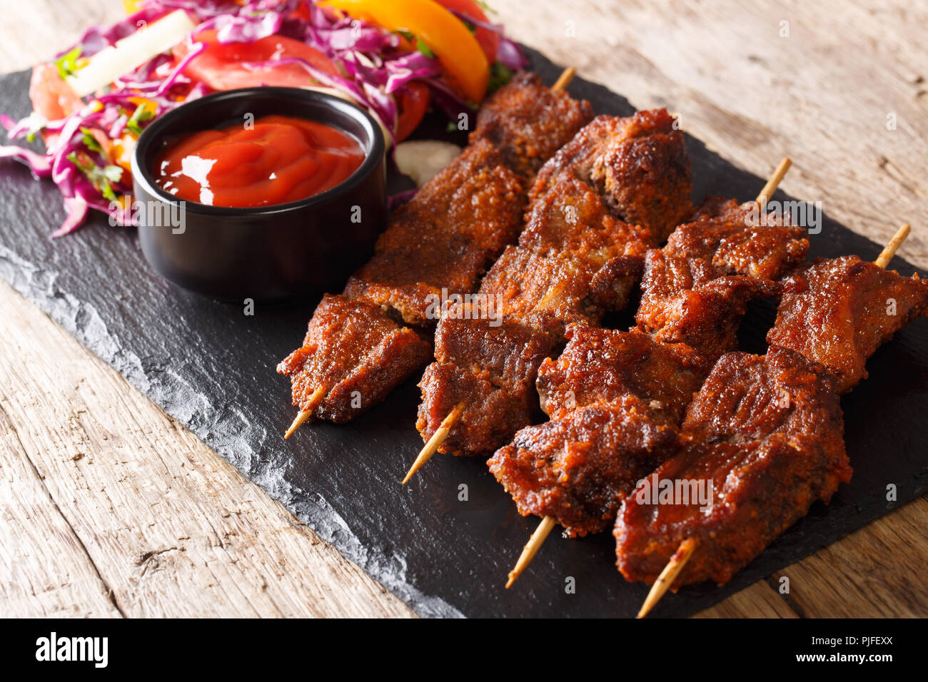 Recipe of a spicy African suya kebab on skewers with fresh vegetable ...