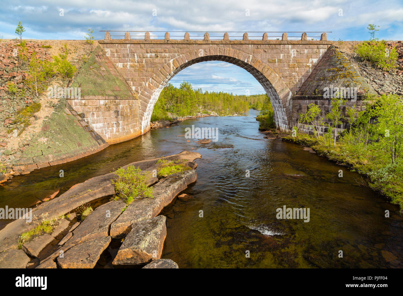 Old railroad bridge made of bricks with a portal, running water from ...