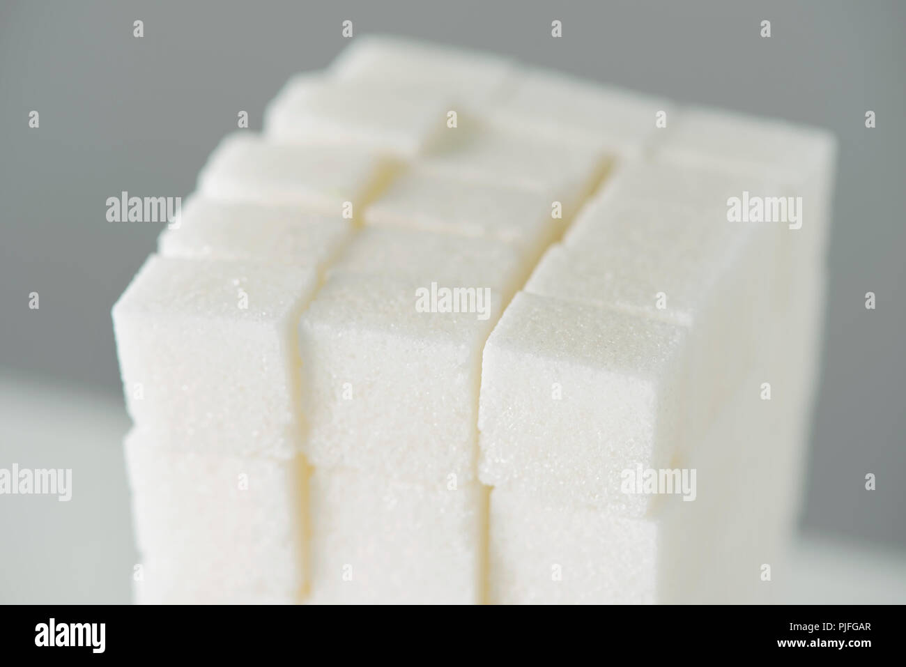 closeup of a pile of white sugar cubes, disposed in a block, on an off ...