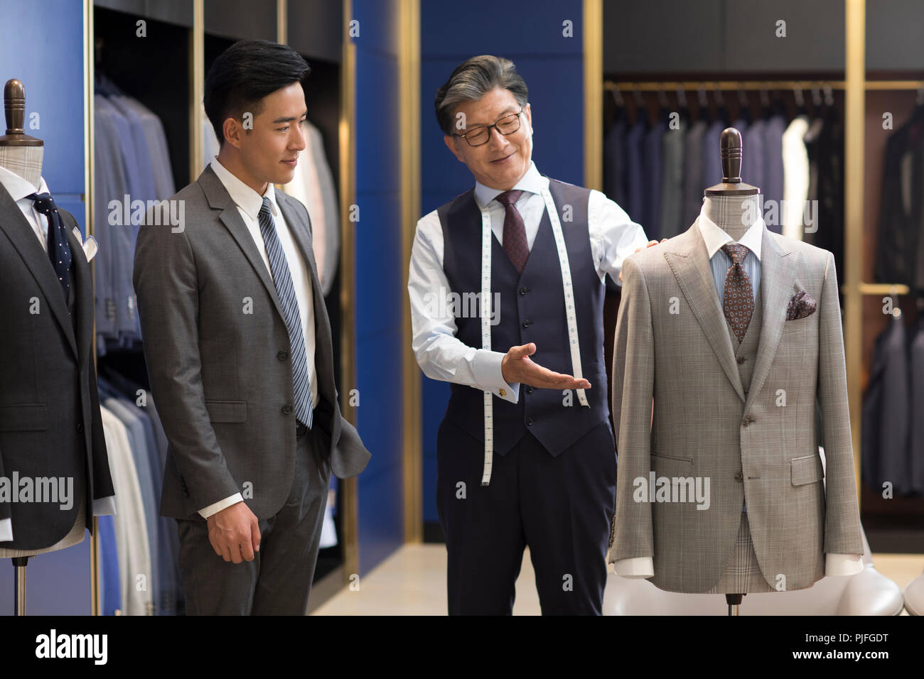 Fashion designer showing customer business suit Stock Photo - Alamy