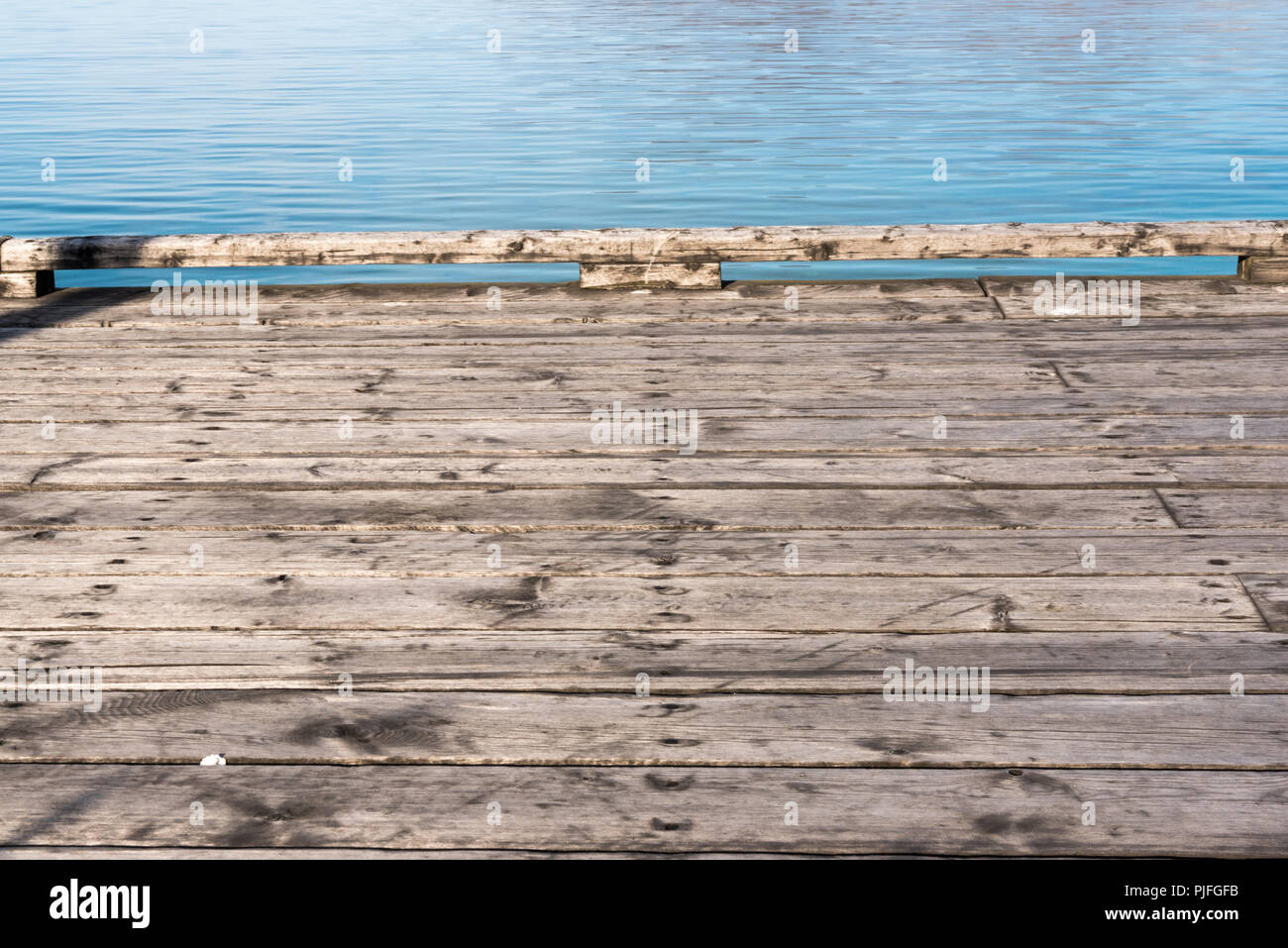 Wooden Boardwalk Jetty Pier with Still Ocean Water with Mountains in ...