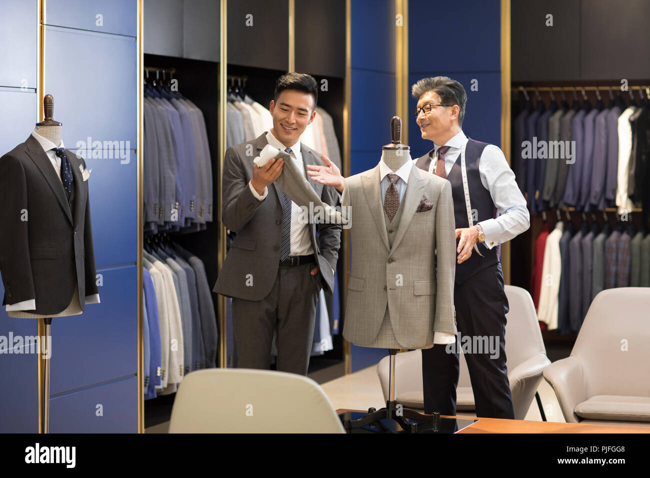 Fashion designer showing customer business suit Stock Photo - Alamy