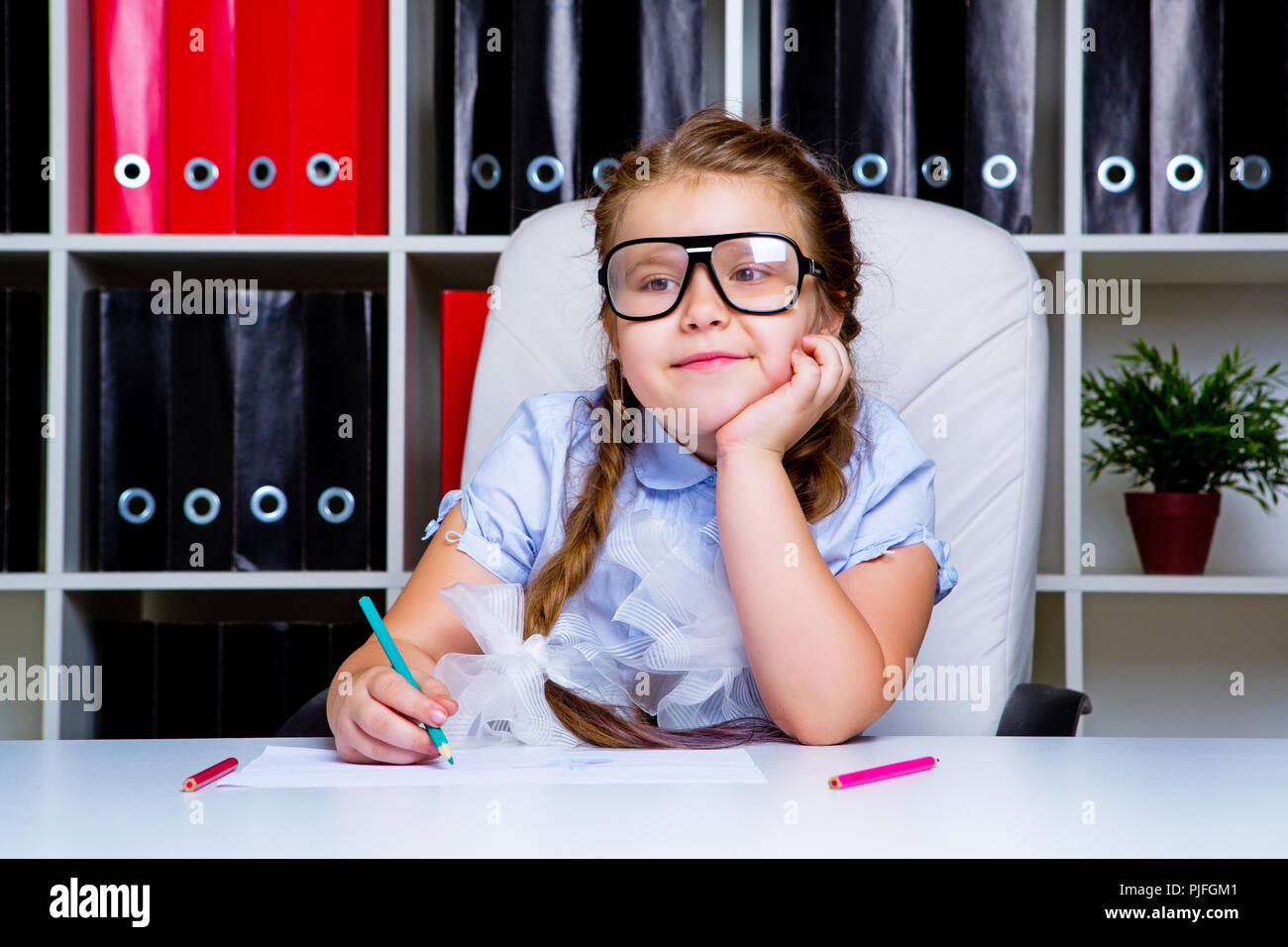cute little girl wearing glasses doing homework Stock Photo - Alamy