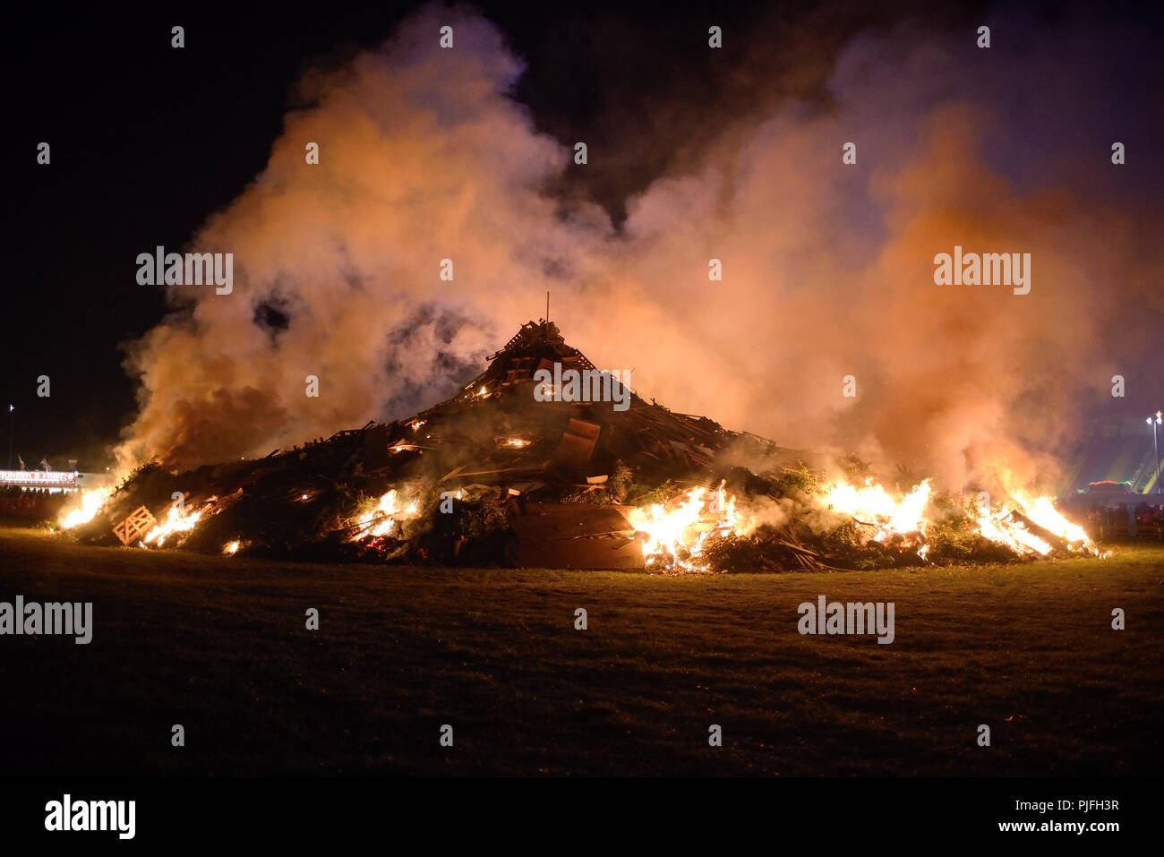 Flames and smoke from a large bonfire after it's been lit during ...