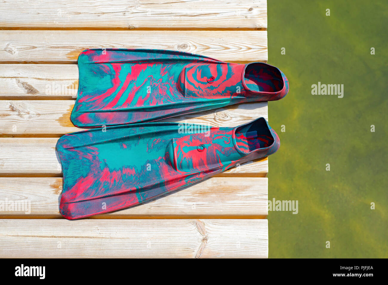 Colourful flippers for diving on wooden pier near the water Stock Photo ...