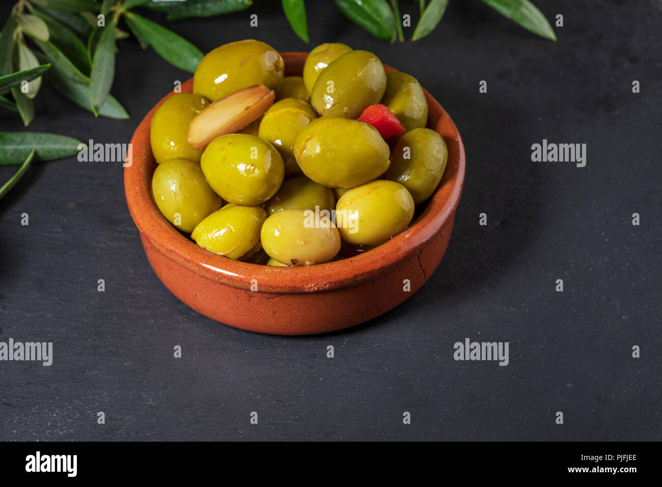 Clay pot with artisan olives (preserved in extra virgin olive oil ...