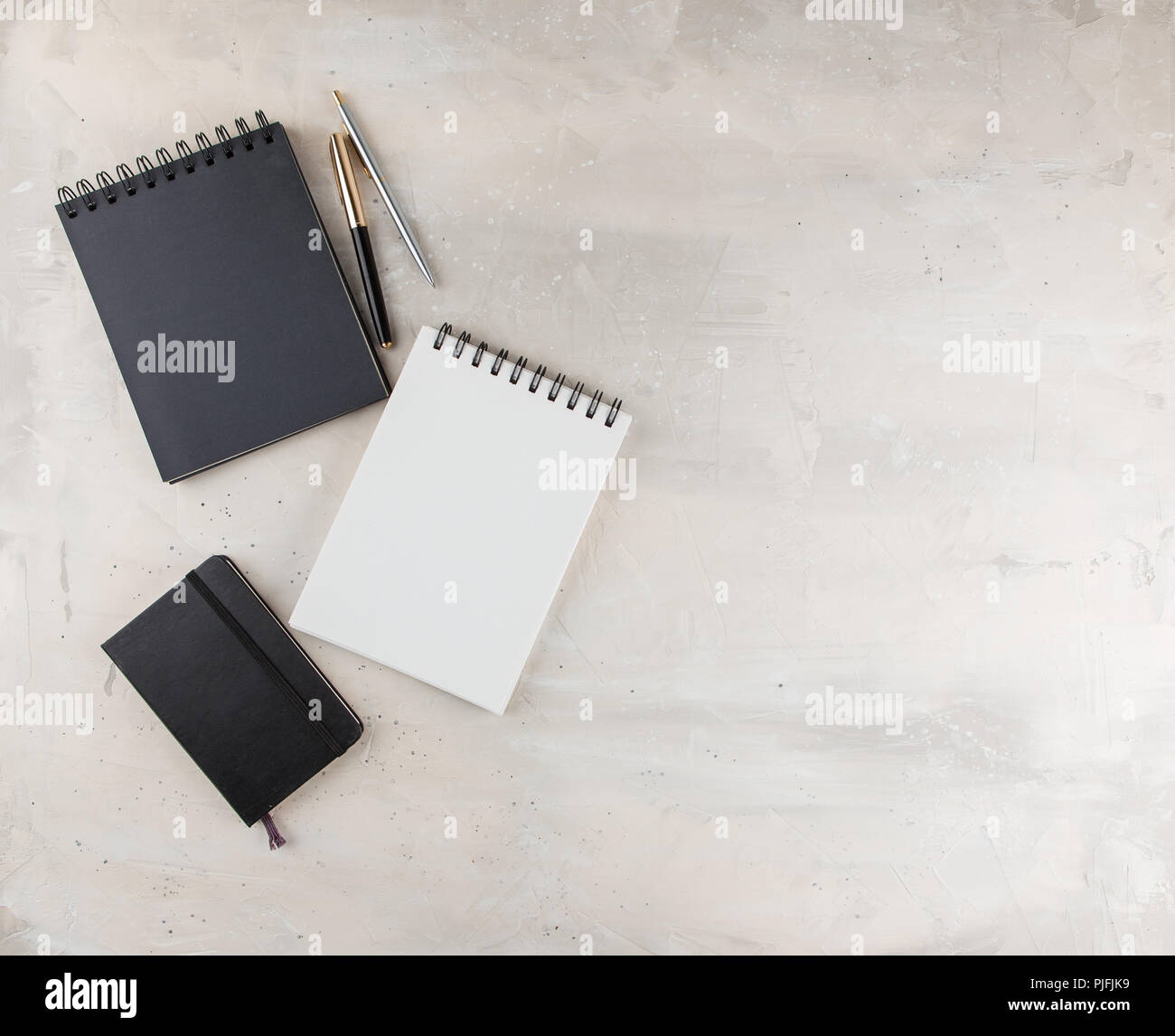 Empty note pad for notes, pens, glasses on the table. Top view with ...