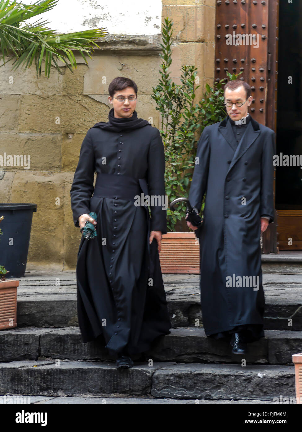 Italy, Tuscany, Florence, two priests wearing cassocks and getting out ...