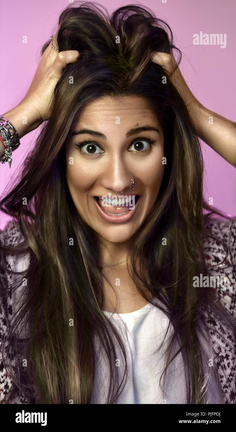 Crazy face girl grabs her hair and laughs with a tremendous surprise ...