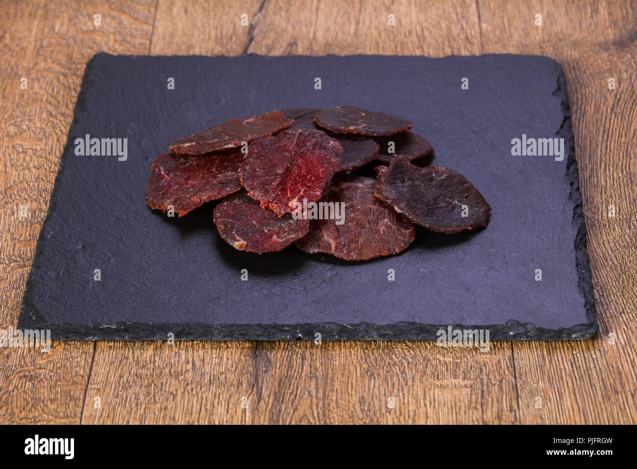 Dry beef meat over wooden Stock Photo - Alamy