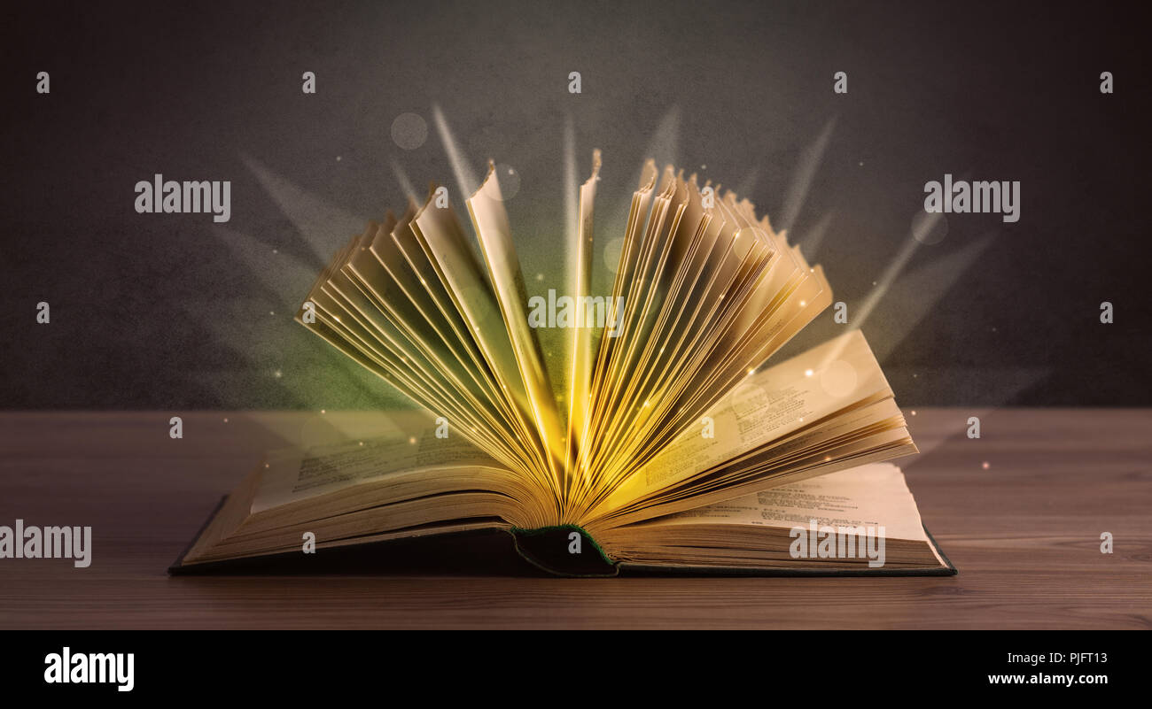 Yellow lights spreading from an open book Stock Photo - Alamy