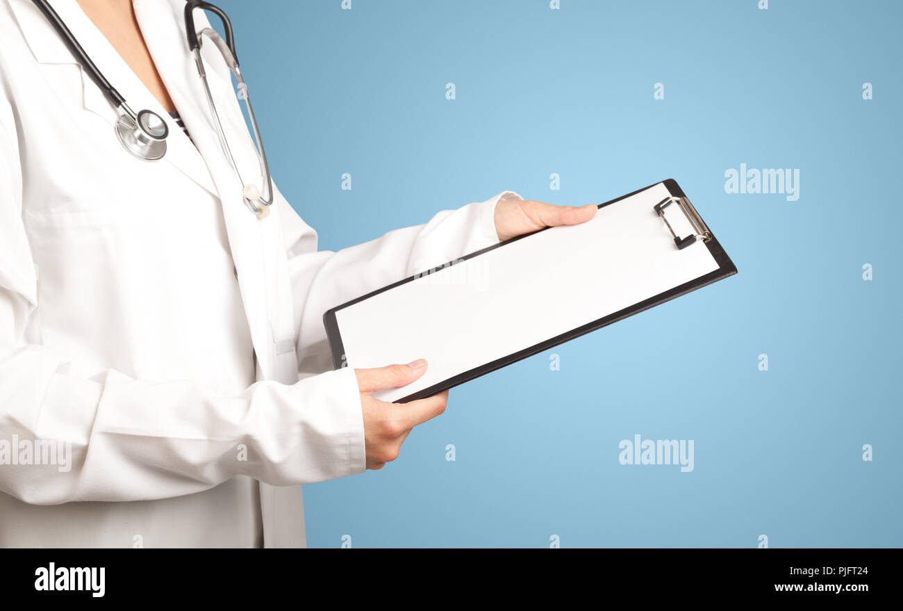 Female doctor holding notepad with blue background Stock Photo - Alamy