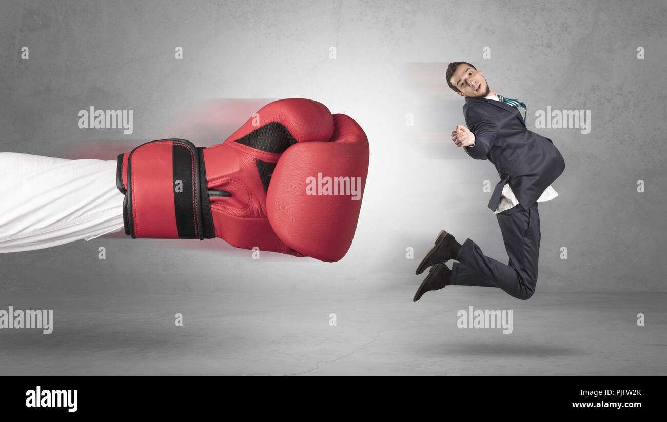 Businessman gets a hit from a giant hand with boxing gloves Stock Photo ...