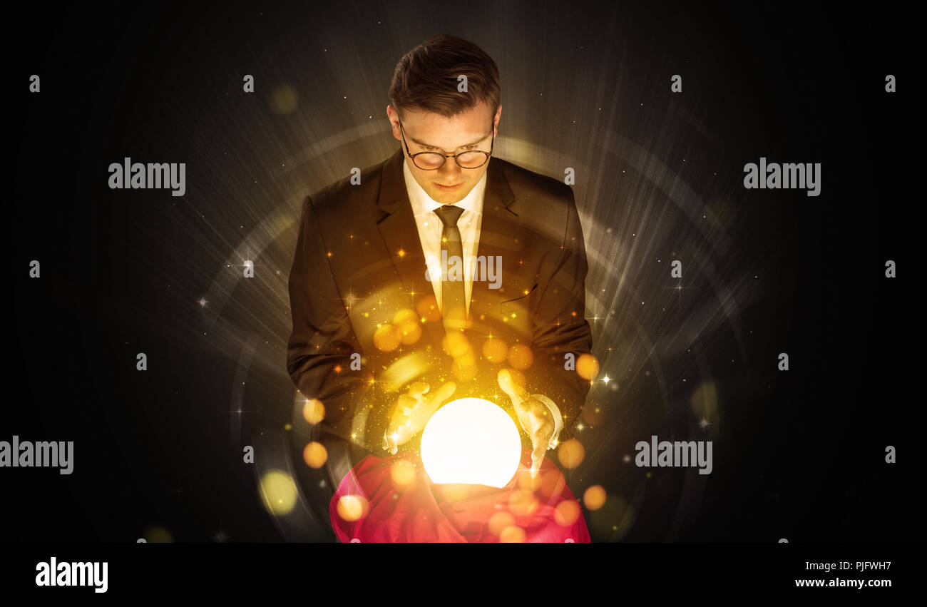 Gorgeous businessman sitting with sparkling magic ball in his lap Stock ...