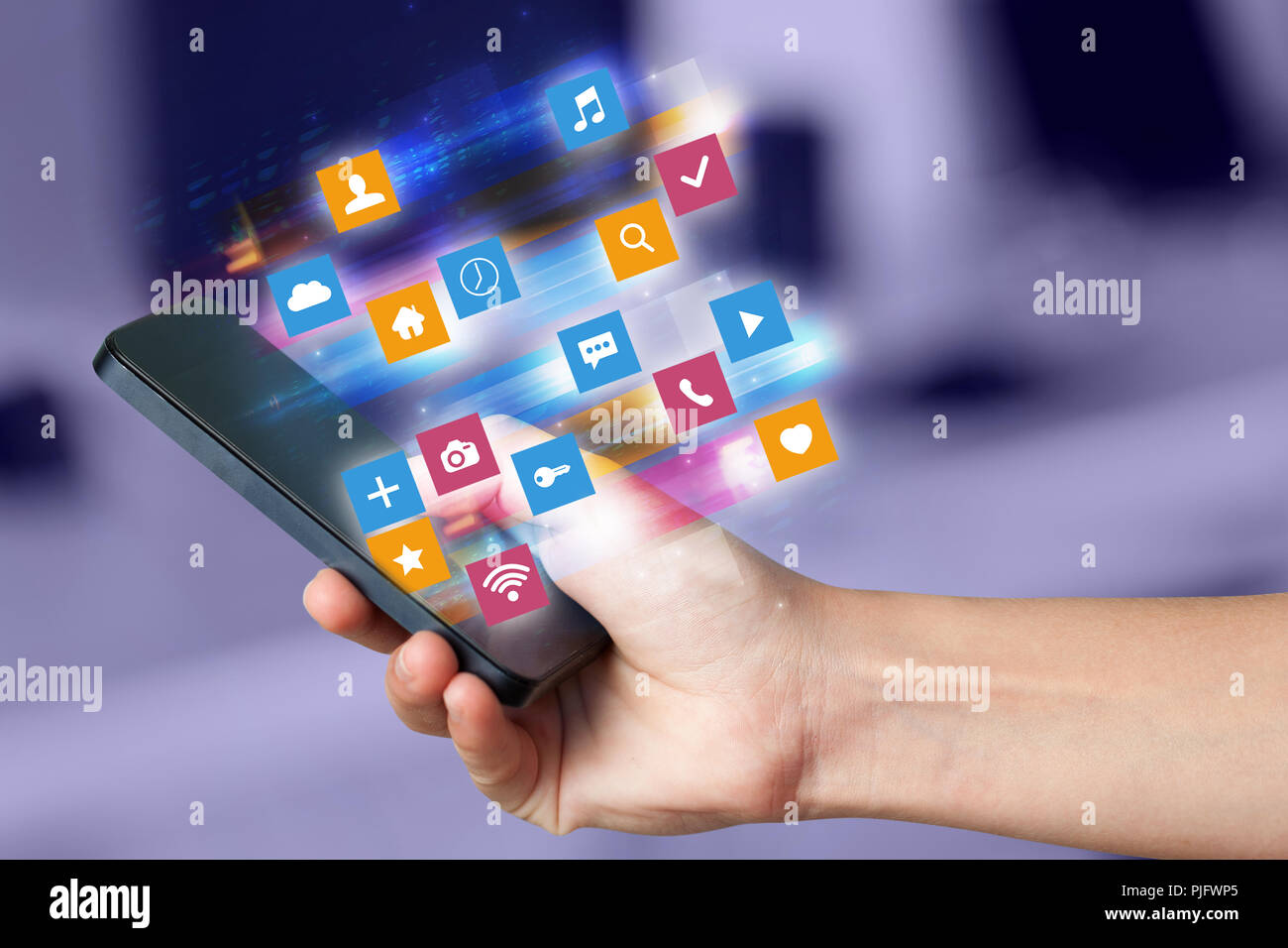 Hand using phone with colorful fast moving application icons and ...