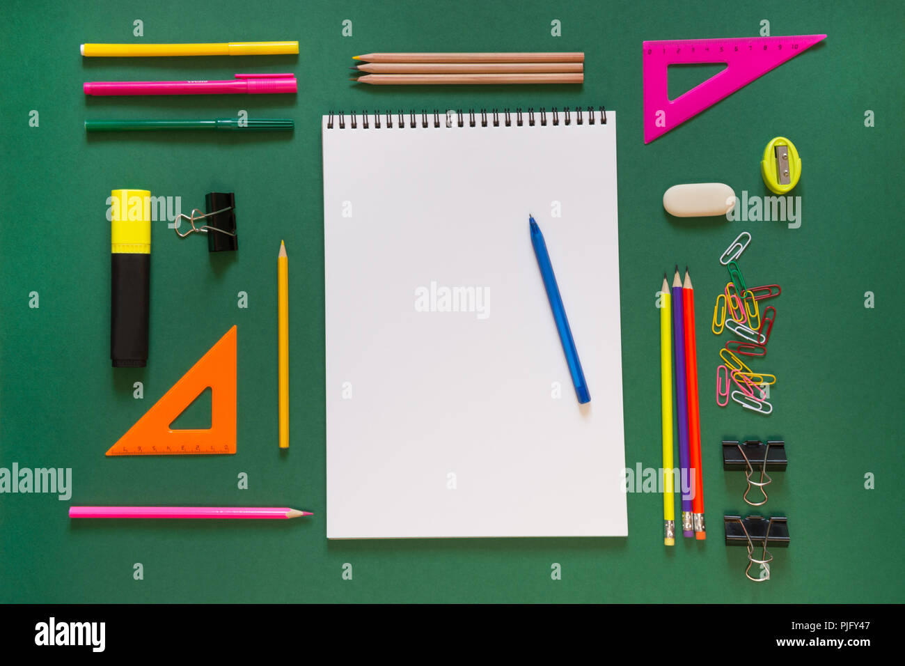 Colorful school supplies and white album on green background. Top view ...