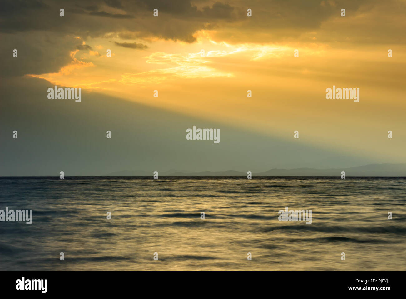 Amazing golden sun-rays passing through the large hole in dramatic ...