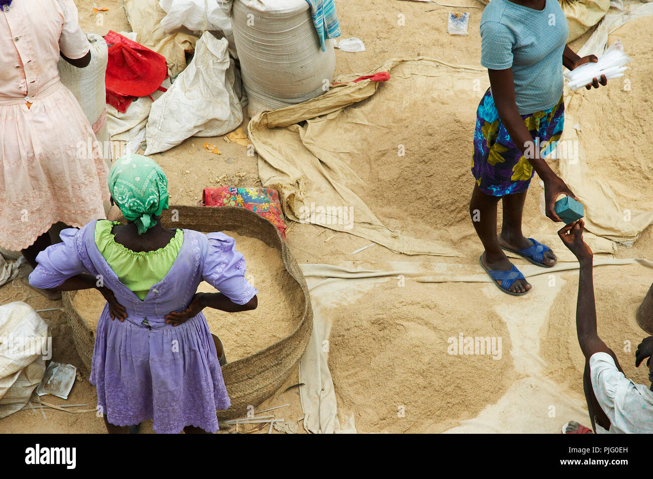 Women sell wheat grain at a market in St Marc while a small blue box is ...
