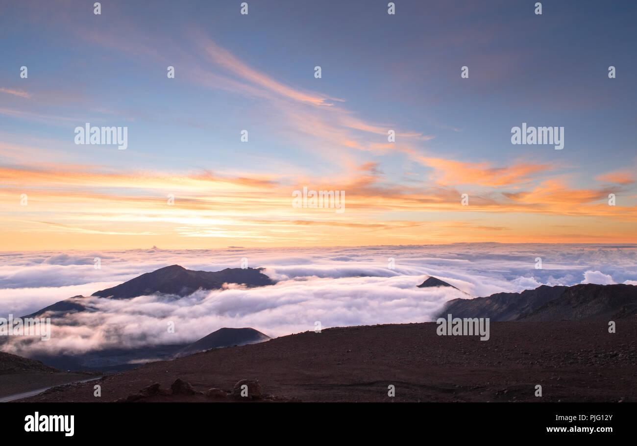 A blazing morning sun slowly rises over a shroud of clouds in the ...