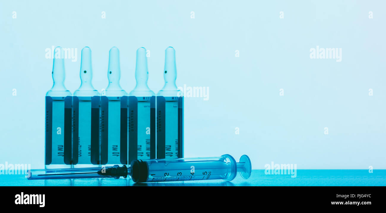 ampoules with a solution for injection and a disposable syringe on a ...