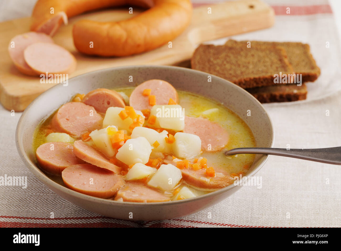 Dutch soup with smoked sausage Rookworst on a rustic table Stock Photo ...