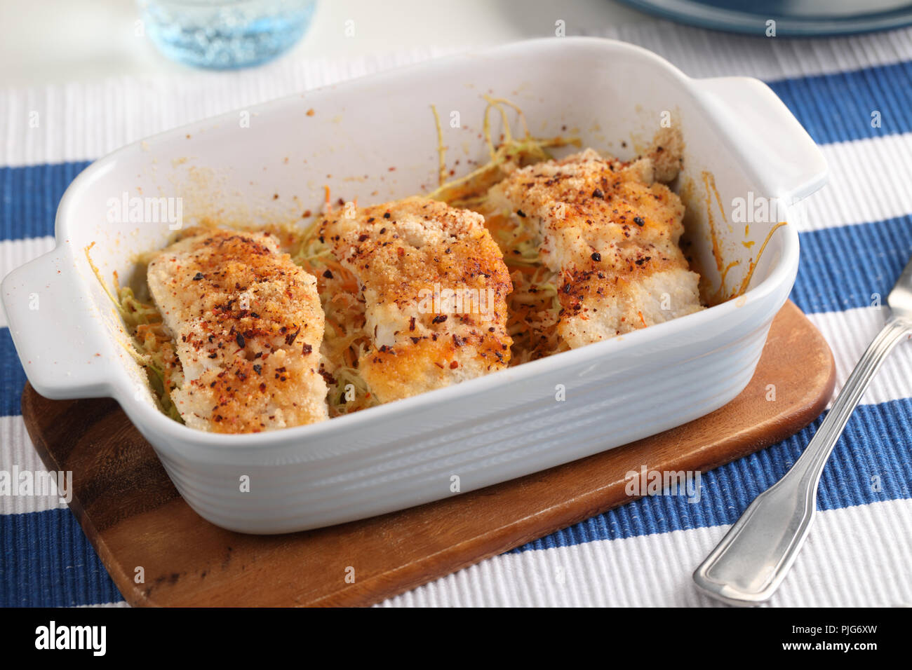 Baked breaded cod fish on vegetable bed Stock Photo - Alamy