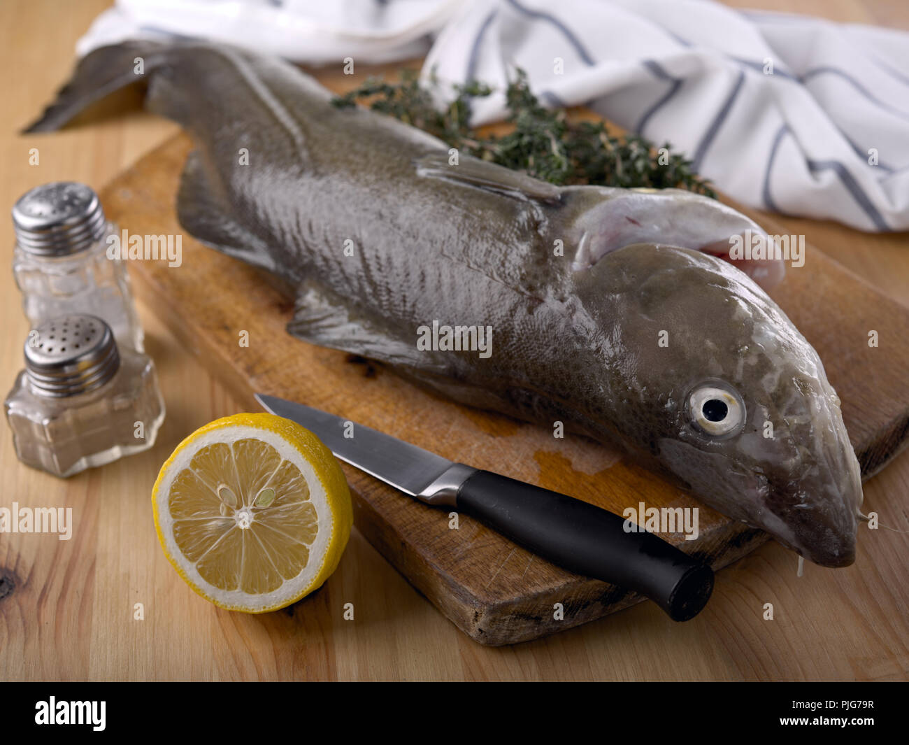 Raw cod fish on a rustic cutting board Stock Photo - Alamy