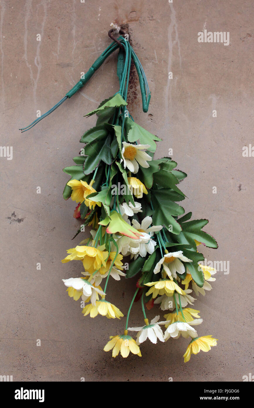Plastic flowers bouquet hanging backwards in a Poblenou cemetery ...
