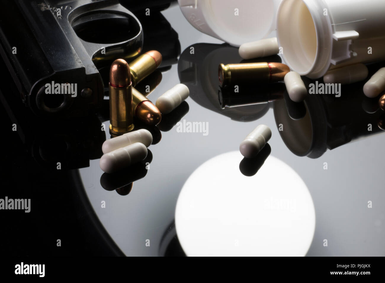 Bullets rolling on a table with a hand gun isolated on black background ...