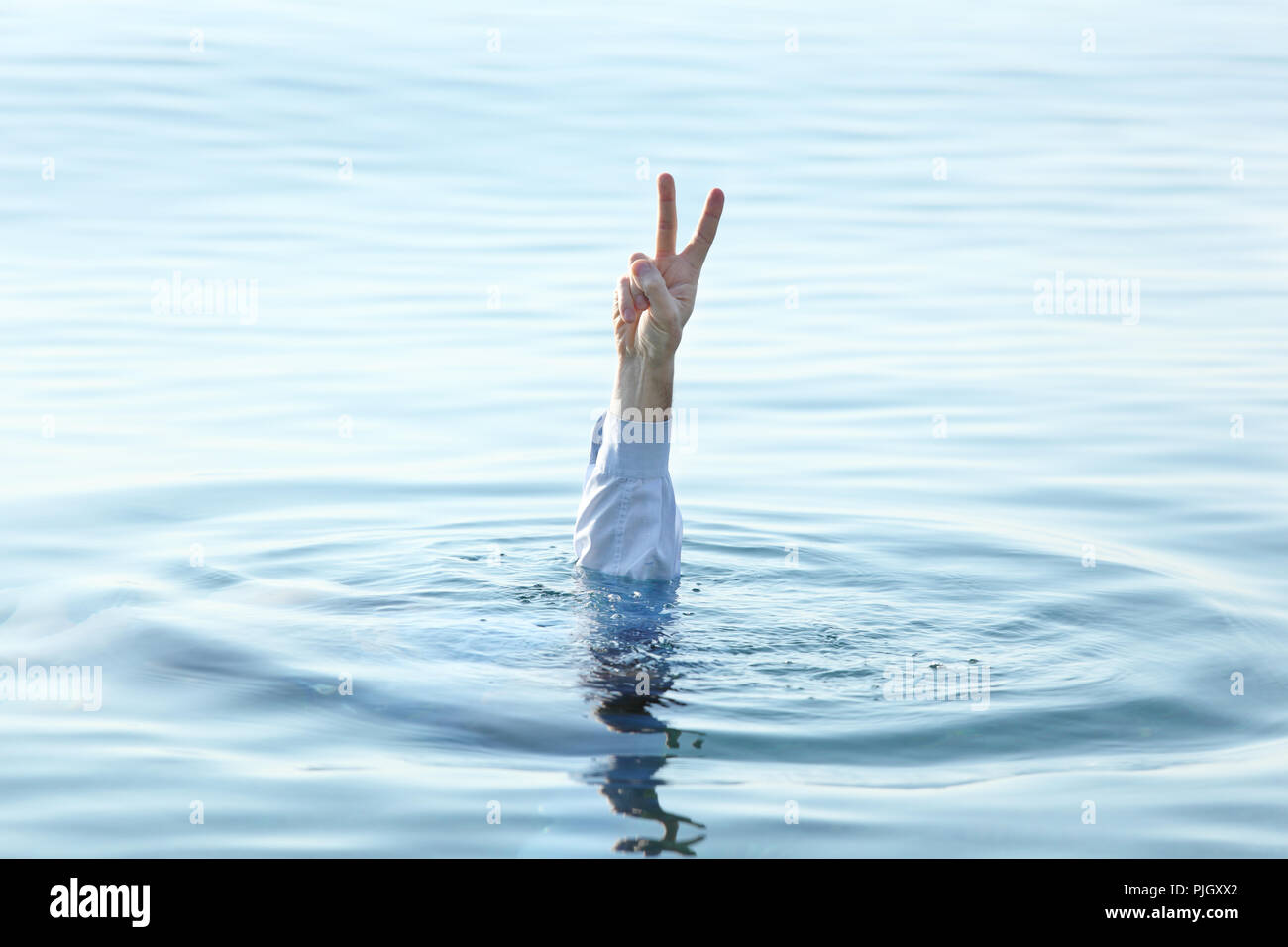 Sinking man showing Victory sign Stock Photo - Alamy