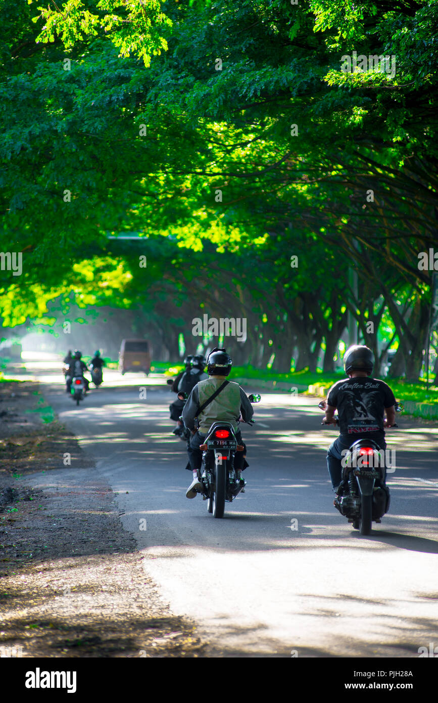 Indonesian men riding bikes in Bali, Indonesia. Jakarta is the biggest ...