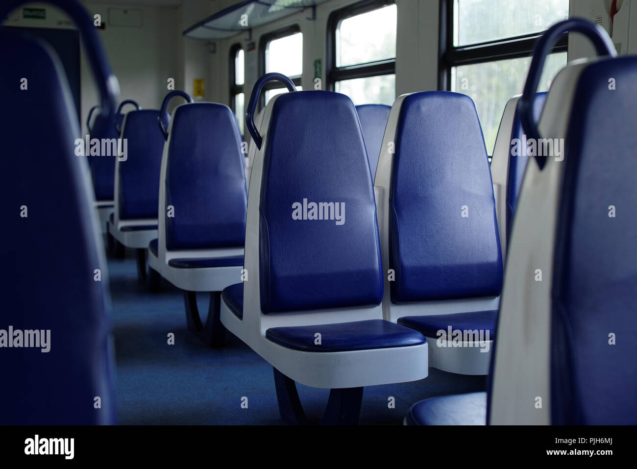 Interior of a commuter train with blue seats Stock Photo - Alamy