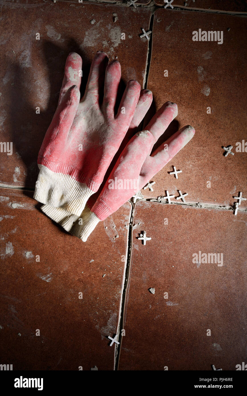Messy protective gloves and tile spacers on a newly installed floor ...
