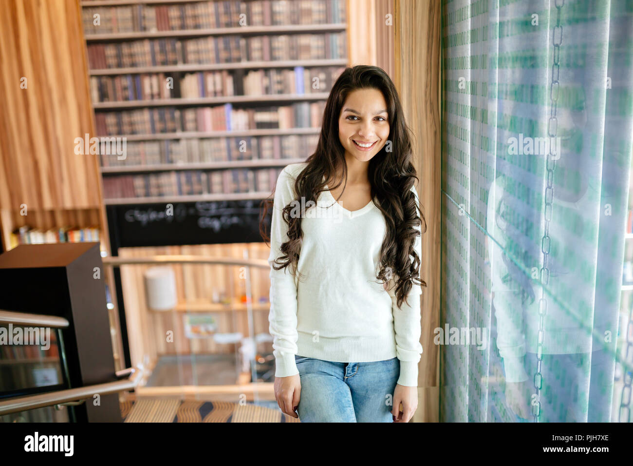 Beautiful brunette in library Stock Photo - Alamy