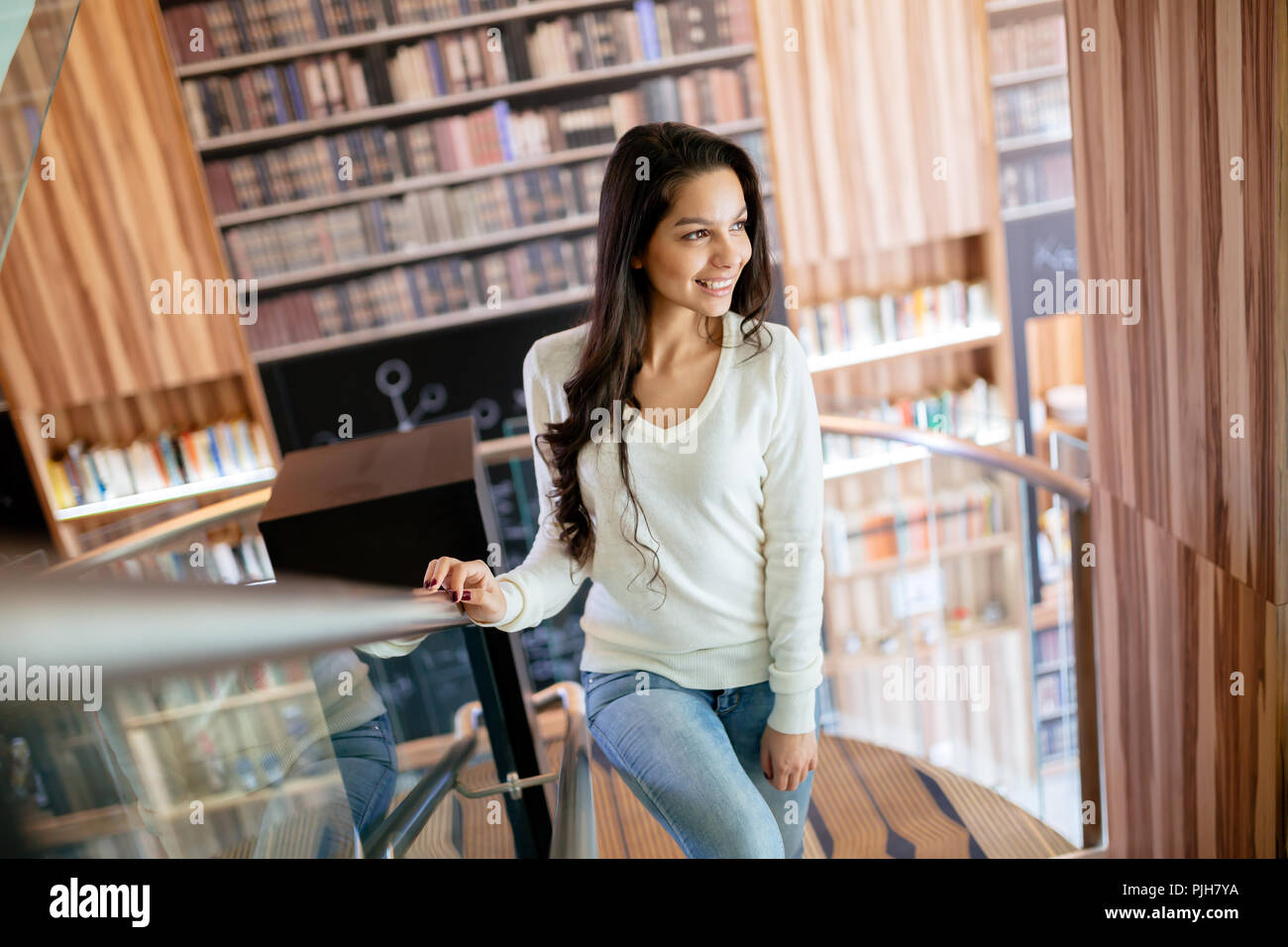 Beautiful brunette in library Stock Photo - Alamy