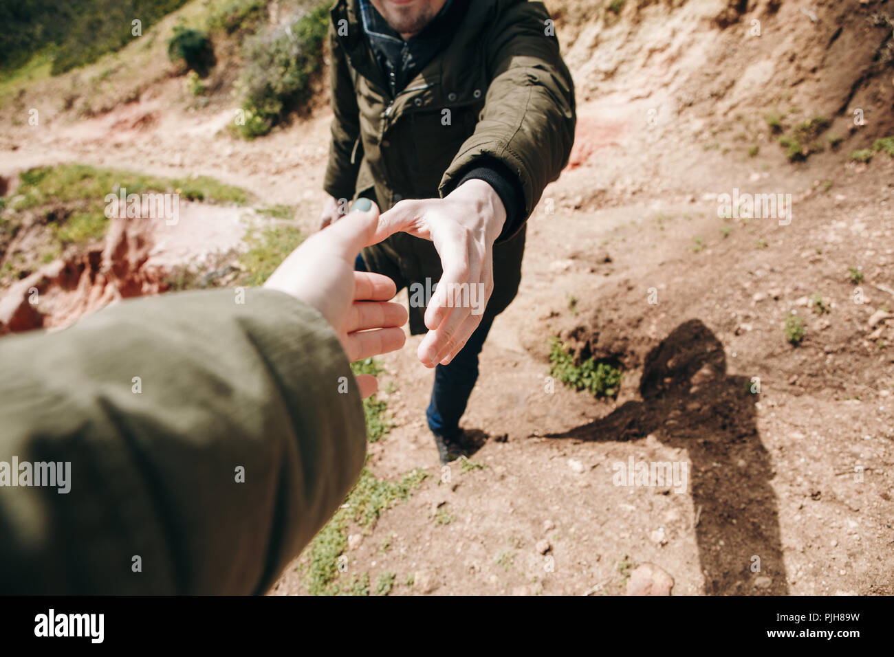 Man helping another man climb hi-res stock photography and images - Alamy