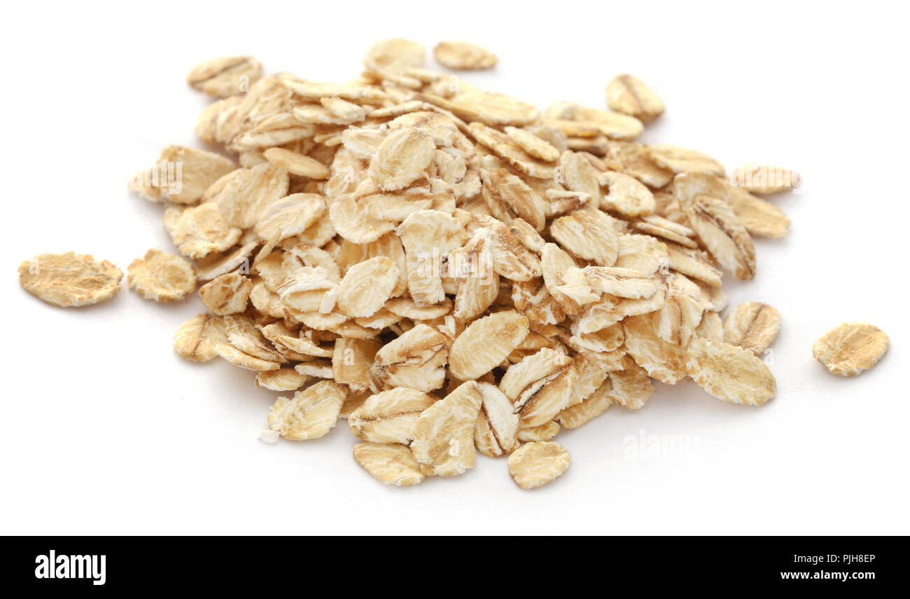 Whole oats in a pile over white background Stock Photo - Alamy