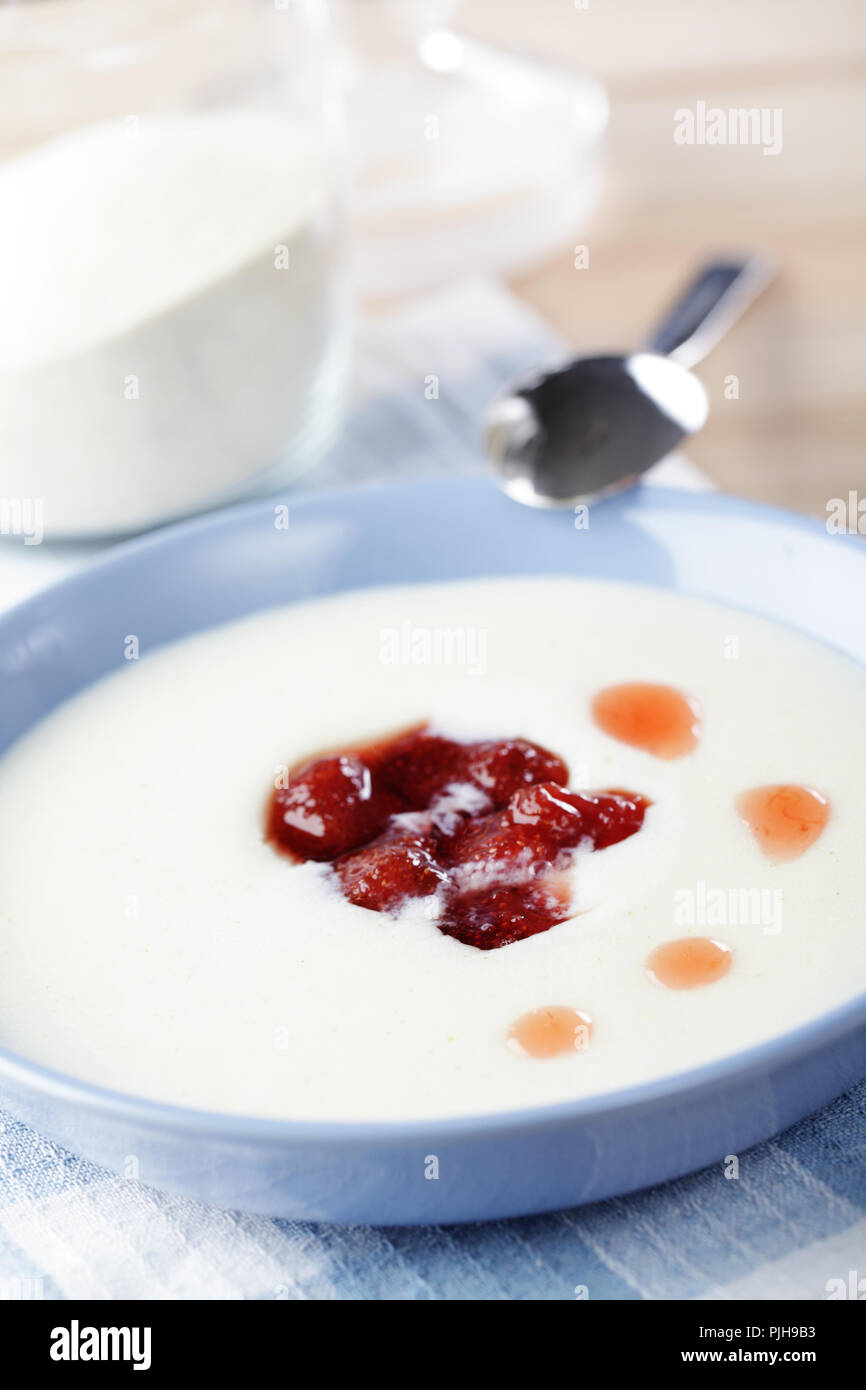 Semolina porridge with strawberry jam in the blue dish Stock Photo - Alamy